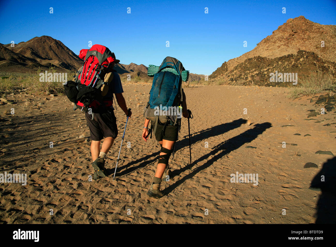 Two hikers walking together on the Fish River Canyon hike Stock Photo ...