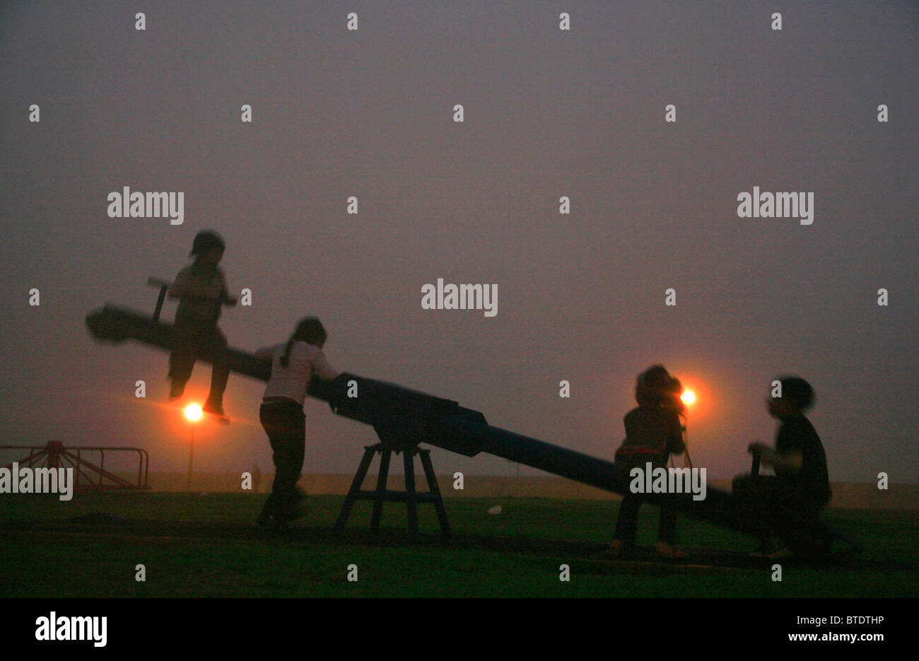 Children playing on playground in the mist Stock Photo - Alamy