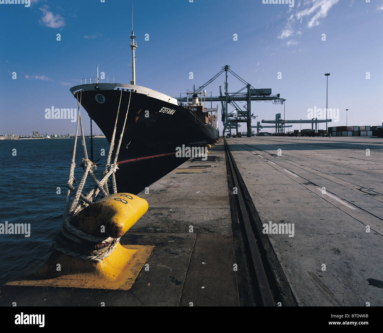 A cargo ship is tightly secured in the wharf as it waits to be loaded ...