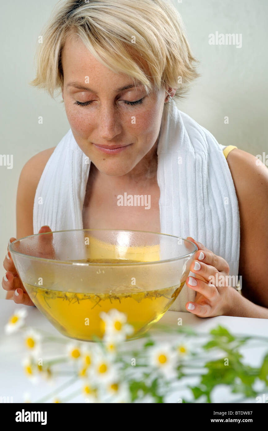 Woman using camomile for inhalation Stock Photo - Alamy