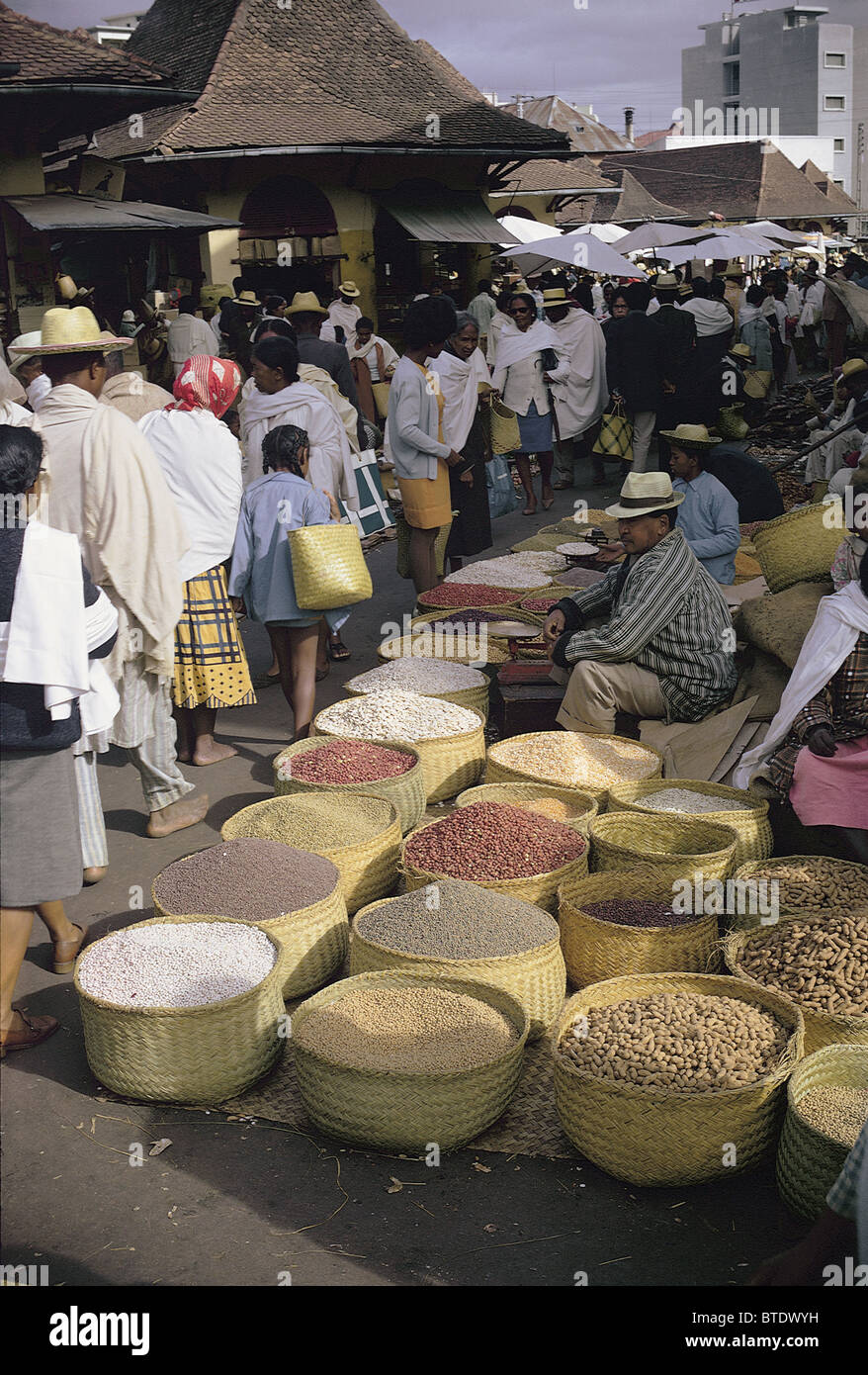 Vendor with baskets of dried goods for sale at the market in ...