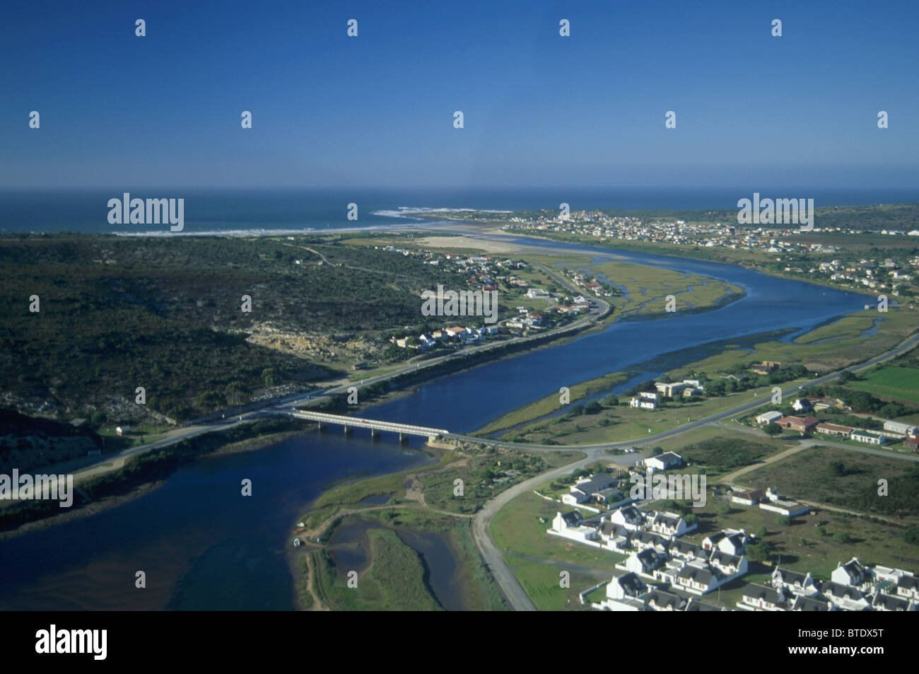 Aerial view of Stilbaai showing a large coastal estuary with a bridge ...