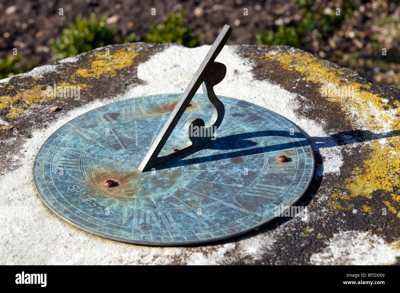Sundial mounted on a plinth with the shadow clearly indicating the time ...