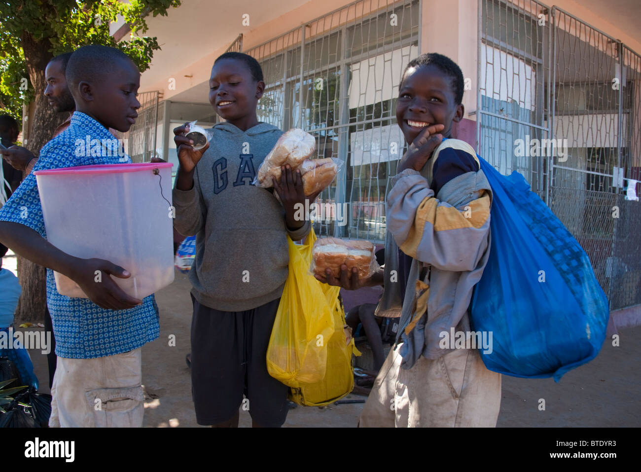 Local boys selling fresh pau bread rolls to passers by Stock Photo - Alamy
