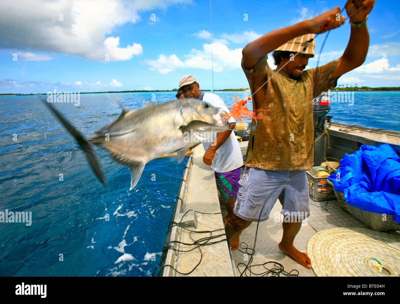 Fisherman catching a fish and pulling it on board Stock Photo - Alamy