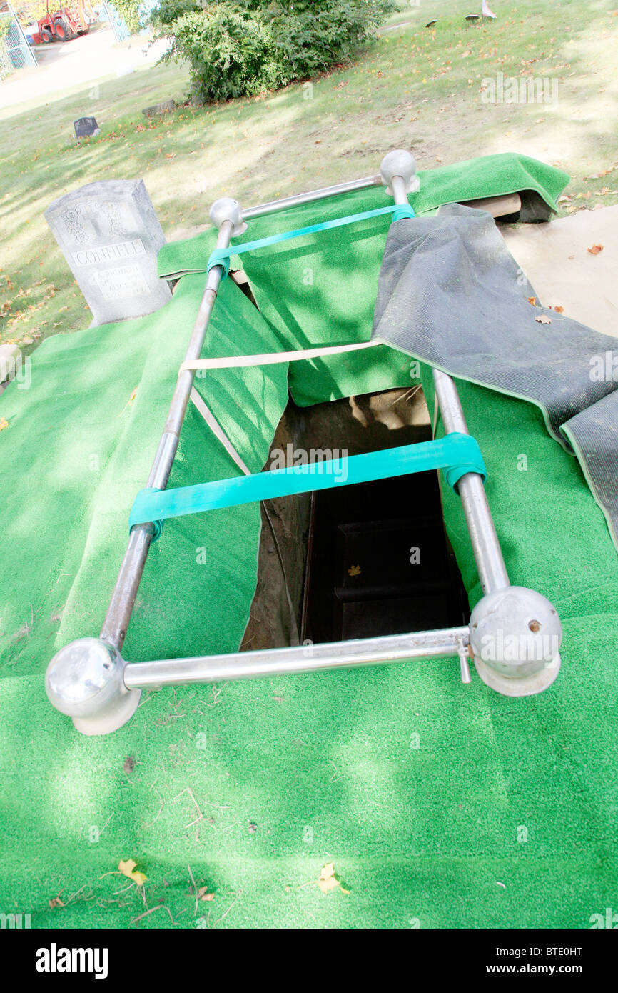 A funeral at a Catholic cemetery in New York,USA showing an open grave ...