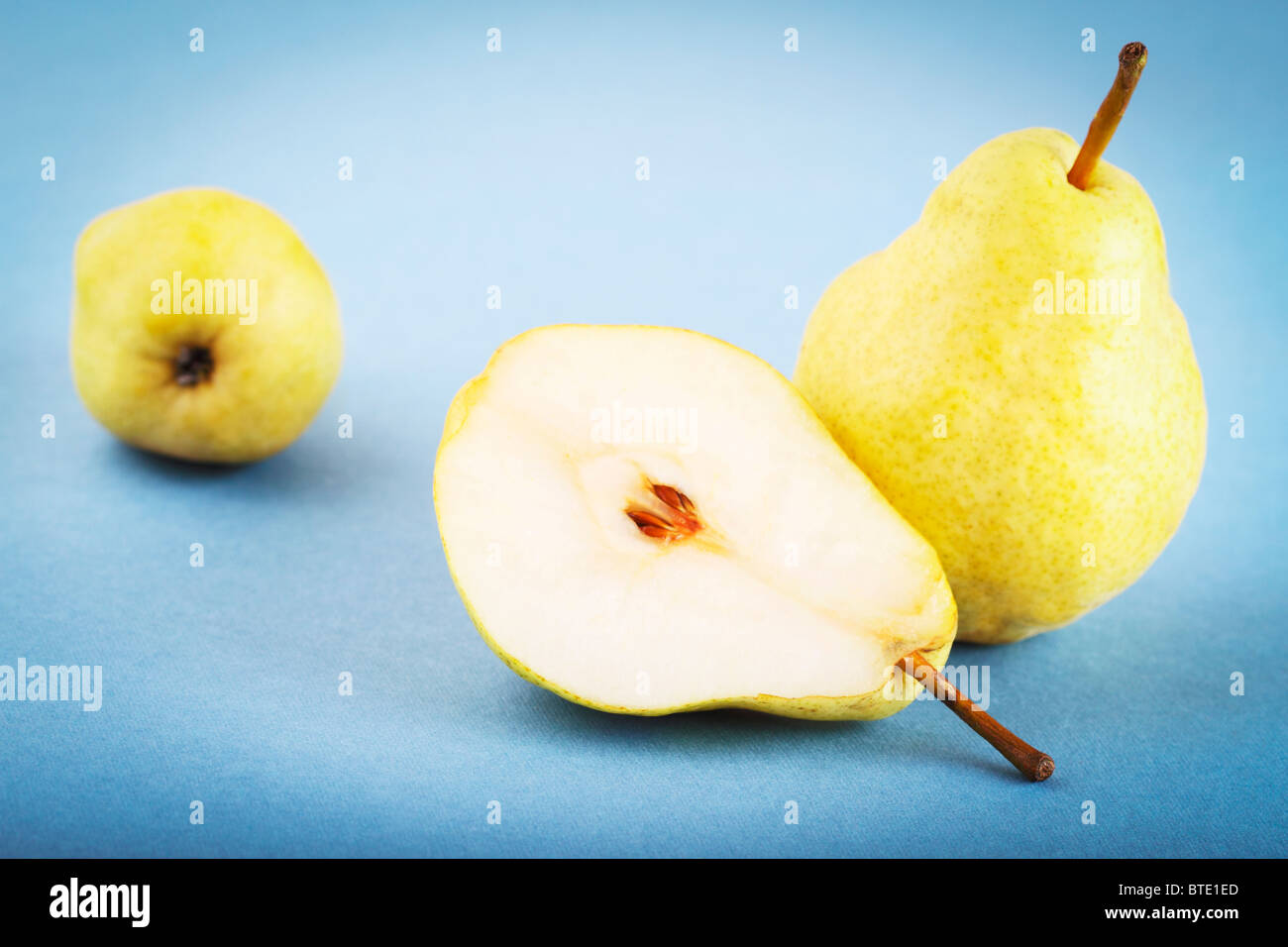 Three yellow pears on the blue background Stock Photo - Alamy