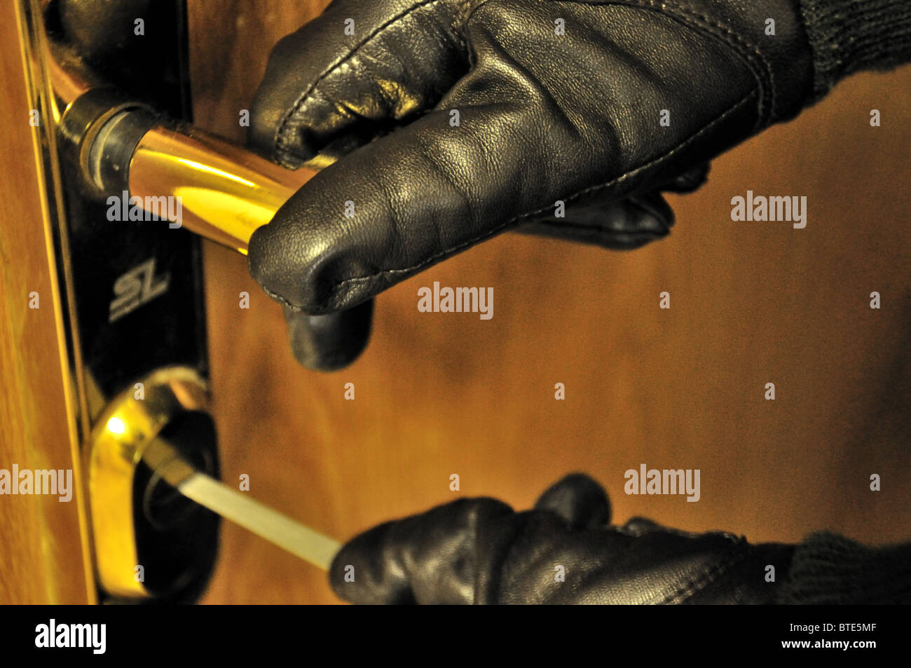 Burglar hands in action for breaking the lock Stock Photo - Alamy