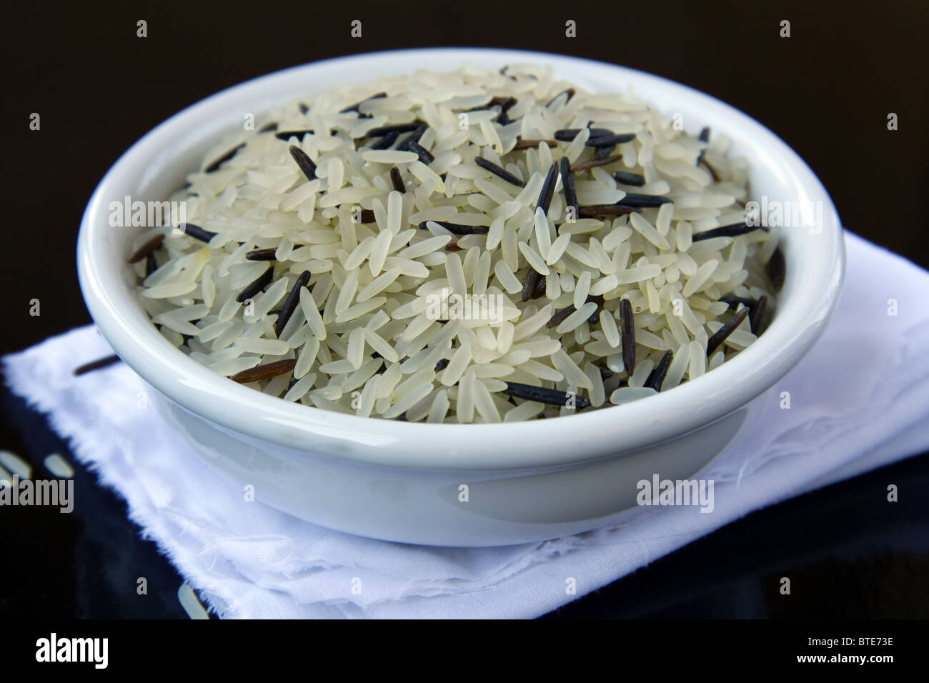 White rice in a cup on black background Stock Photo - Alamy