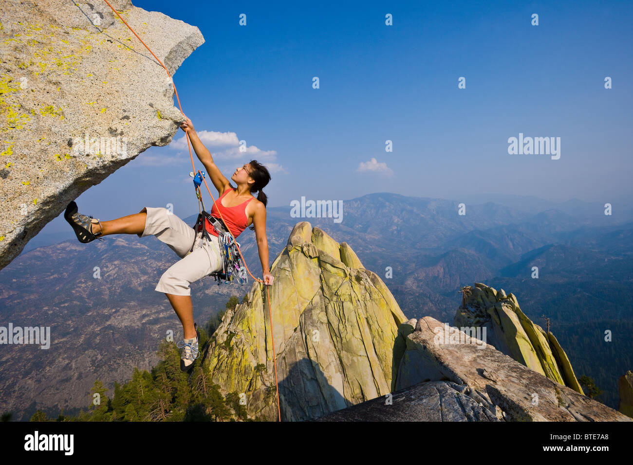 Female climber rappelling from the summit of an overhanging cliff Stock ...
