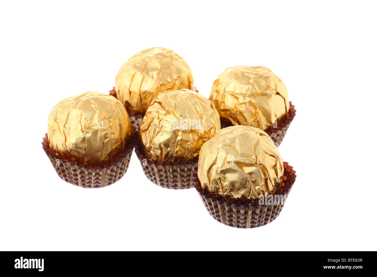 Five luxury golden sweets isolated on white Stock Photo - Alamy
