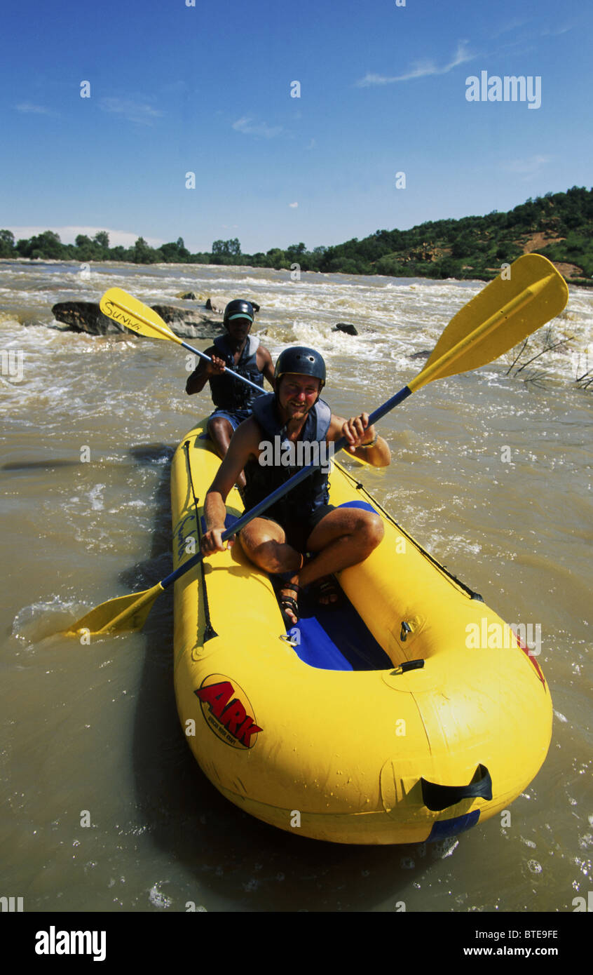 Two paddlers in a yellow inflatable canoe on a Sunwa Safaris trip enjoy ...