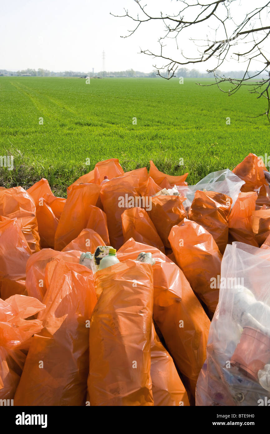 Pile of garbage bags beside field Stock Photo - Alamy