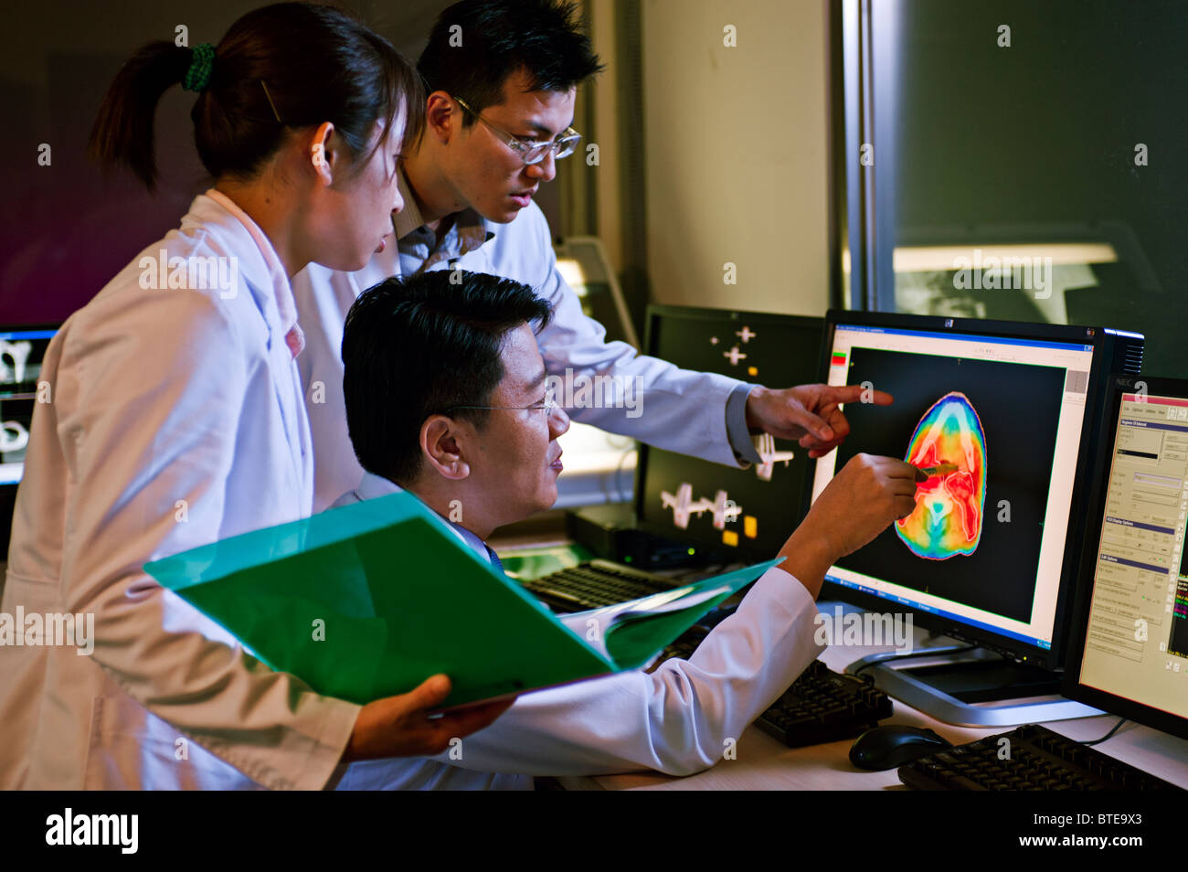 Doctors viewing and discussing CT scan results images on computer ...