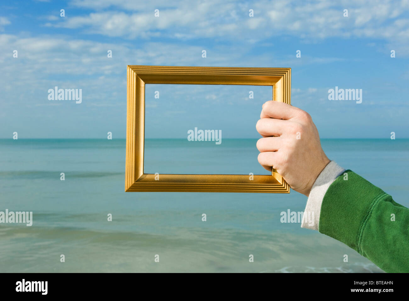 Person holding picture frame in front of ocean Stock Photo - Alamy