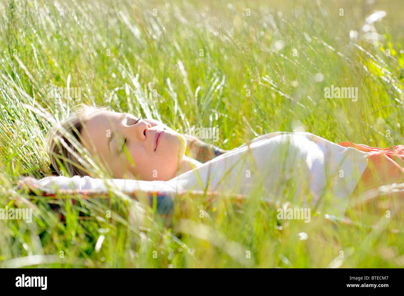 Woman taking nap on grass hi-res stock photography and images - Alamy
