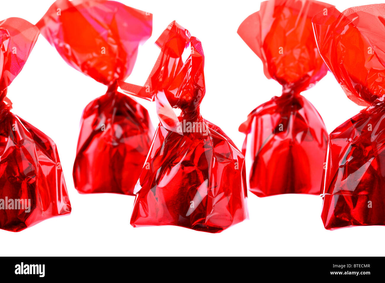 Red luxury sweets in zig-zag row isolated on white Stock Photo - Alamy