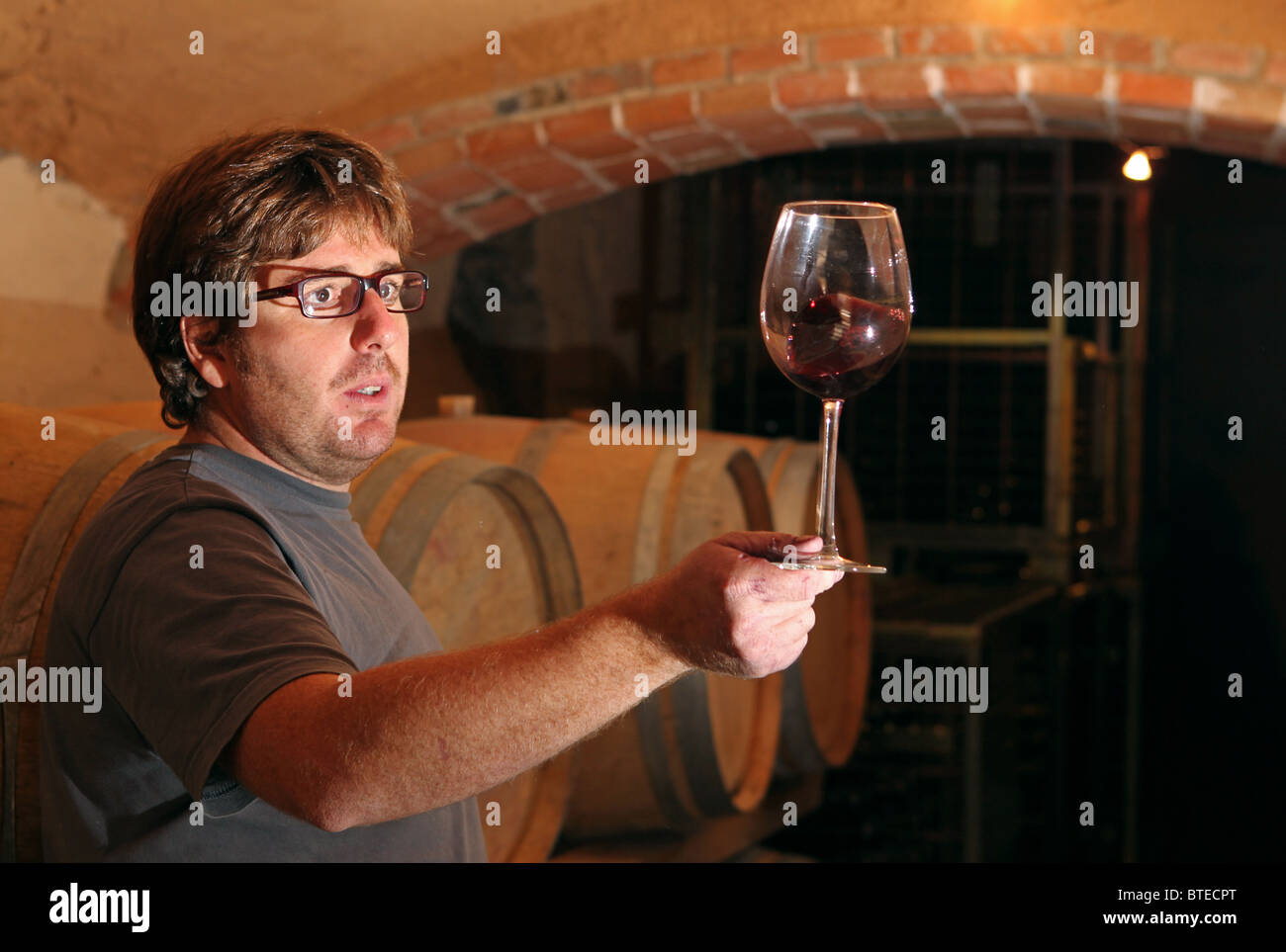 Owner of a winemaking factory in Spain standing in his wine cellar and ...