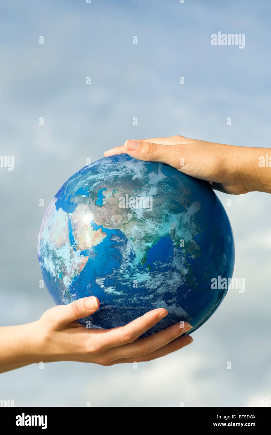 Two people's hands supporting one ball Stock Photo - Alamy
