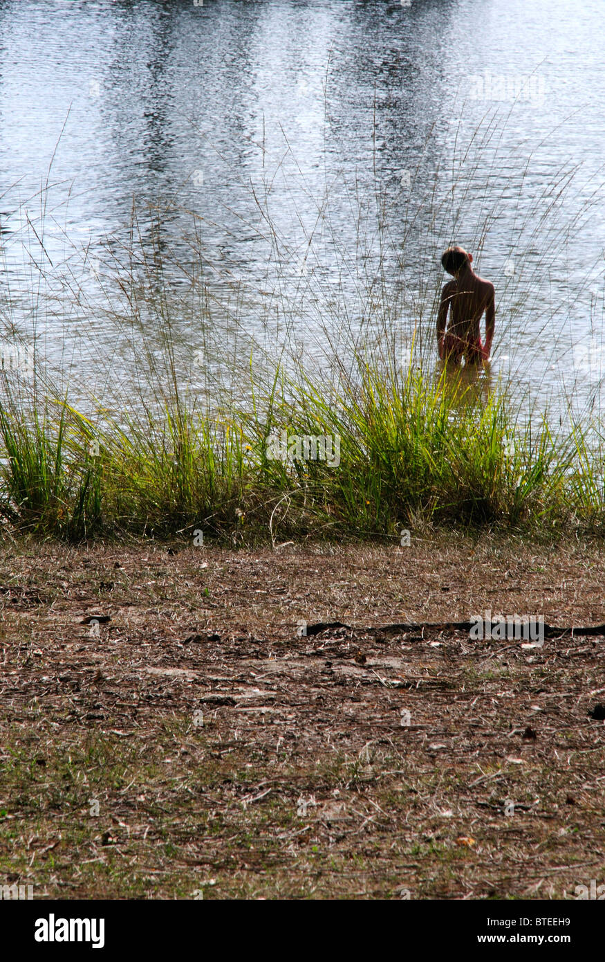 Child wading in lake, rear view Stock Photo - Alamy