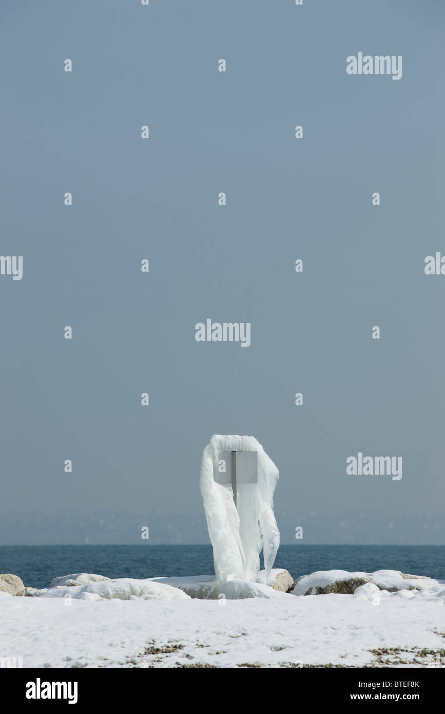Sign covered in ice at water's edge Stock Photo - Alamy