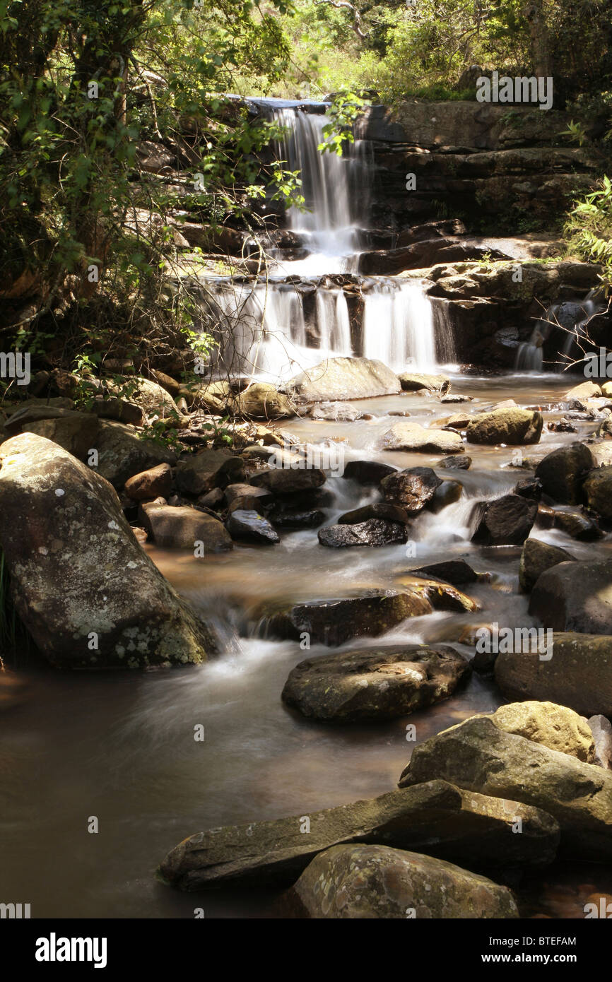 A waterfall flowing down rocks in a stream Stock Photo - Alamy