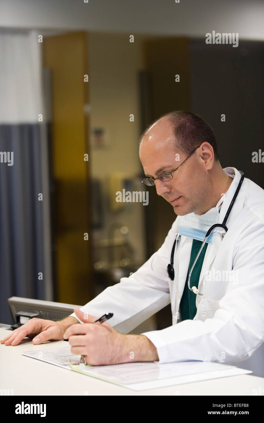 Doctor sits writing hi-res stock photography and images - Alamy