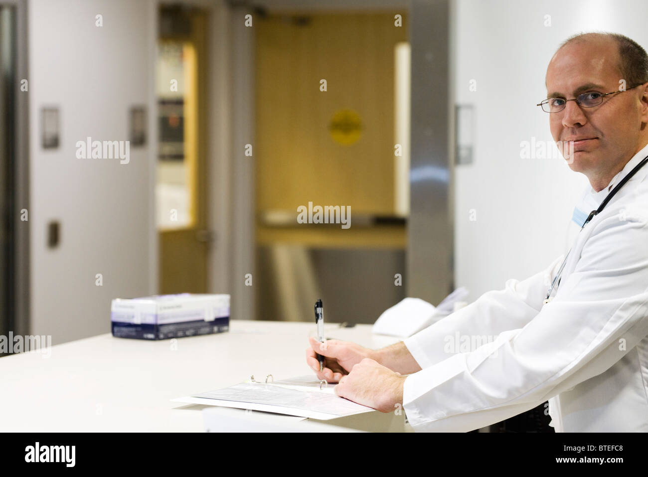 Doctor completing paperwork, portrait Stock Photo - Alamy