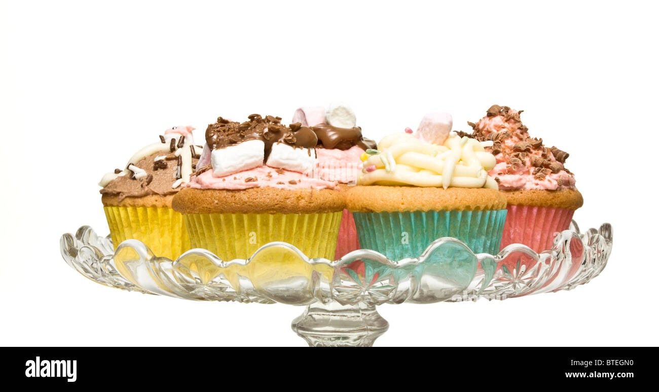 A selection of fancy homemade cupcake on glass pedestal cake stand ...
