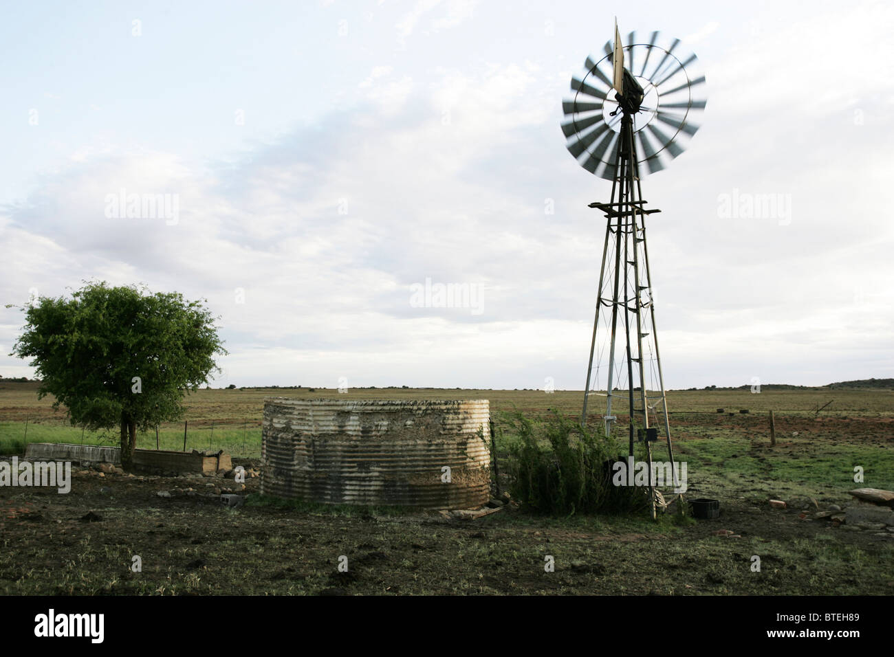 Windmill and water tank with a cloudy sky overhead Stock Photo - Alamy