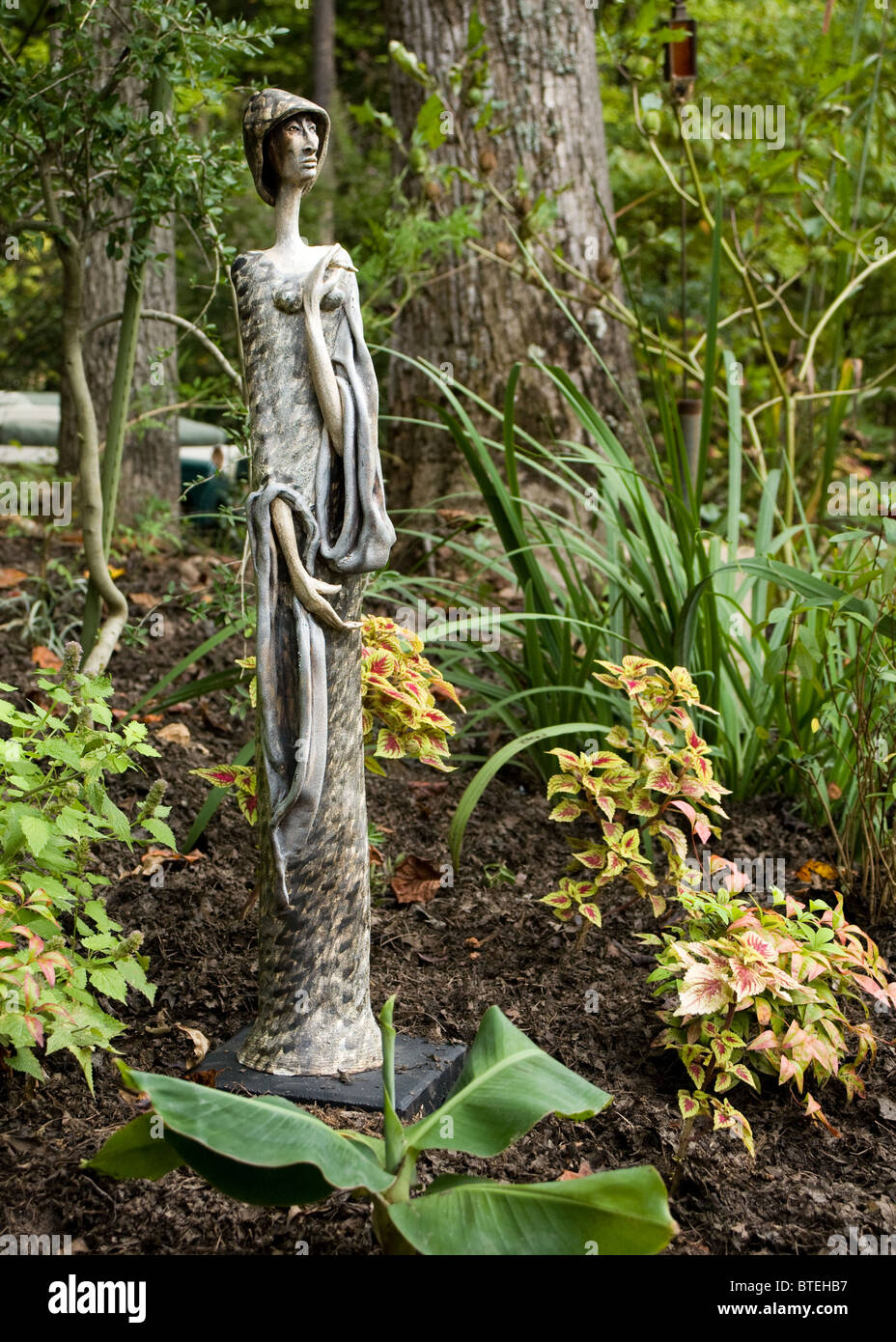Small statue of a woman in the garden Stock Photo - Alamy