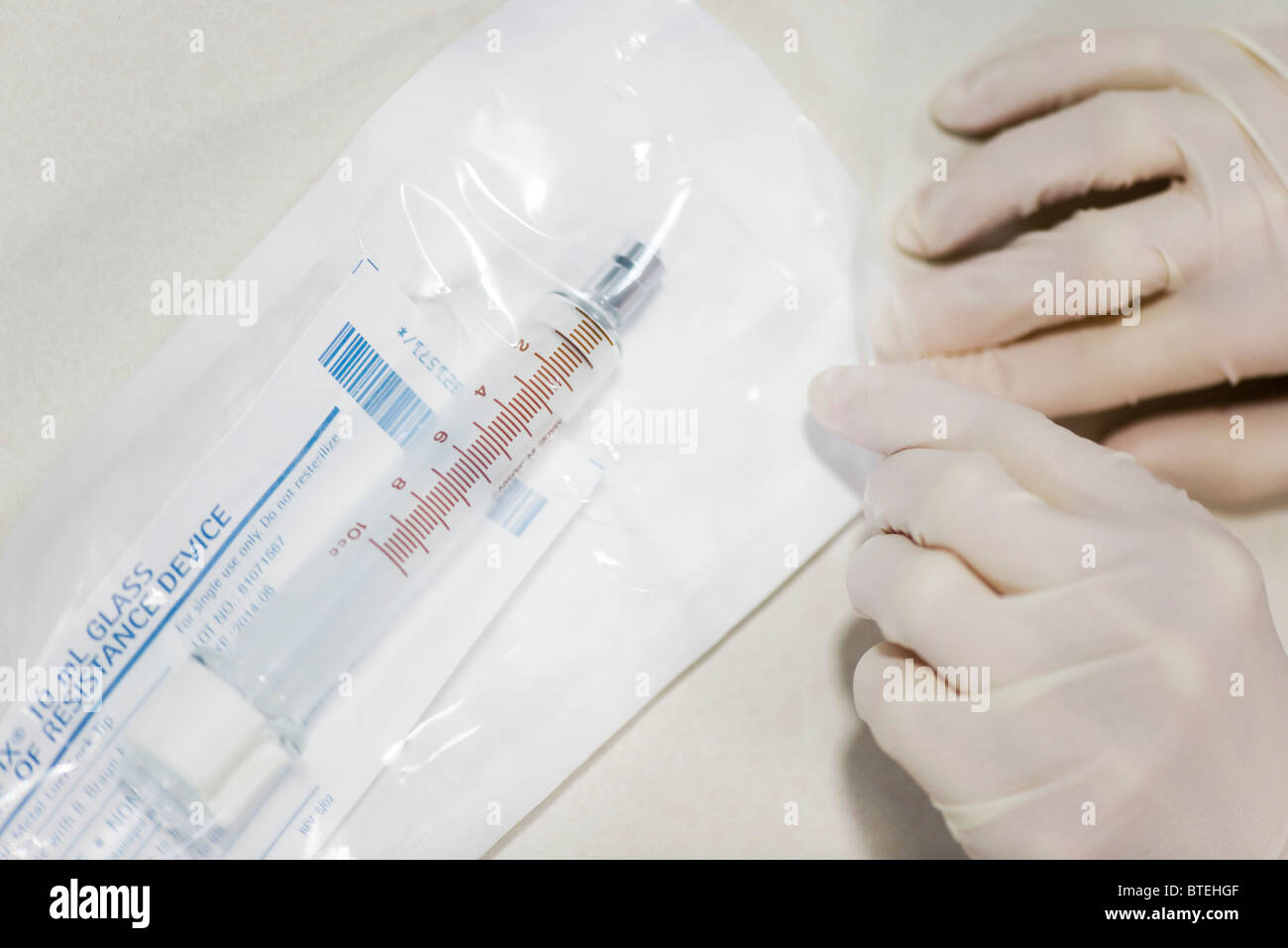 Healthcare worker opening sterile package containing medical syringe ...