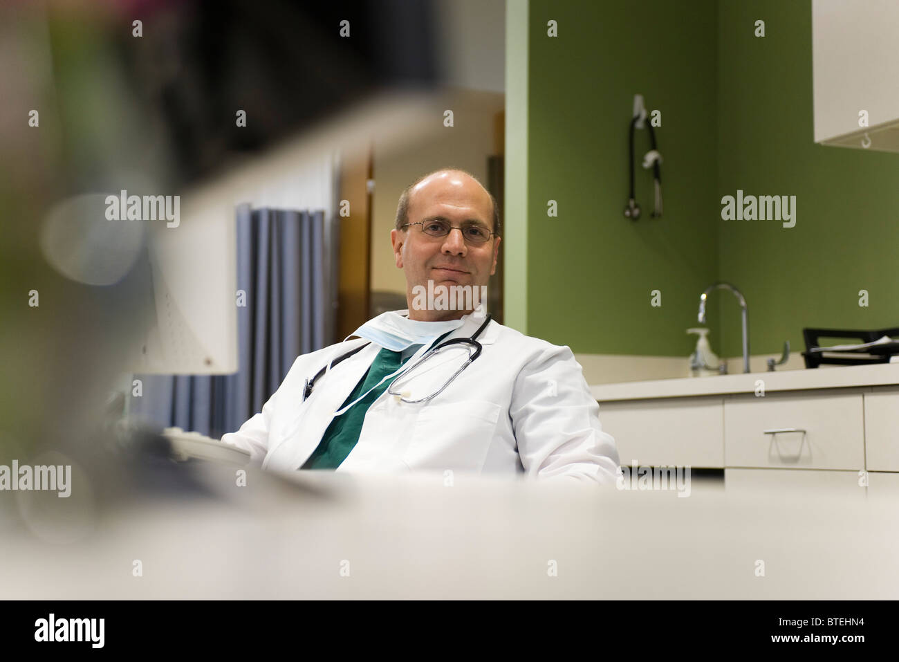 Portrait smiling doctor sits hi-res stock photography and images - Alamy