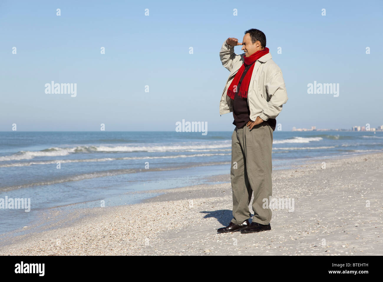 Man standing on beach looking at view Stock Photo - Alamy