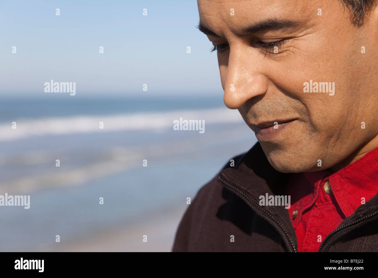 Man at the beach looking down in thought, portrait Stock Photo - Alamy