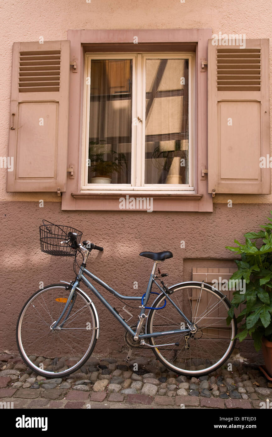 Bicycle parked under a window Stock Photo - Alamy