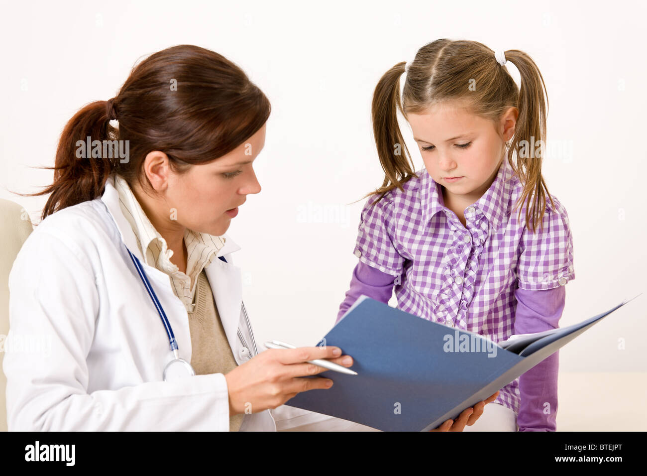 Female doctor with child at medical office showing file Stock Photo - Alamy