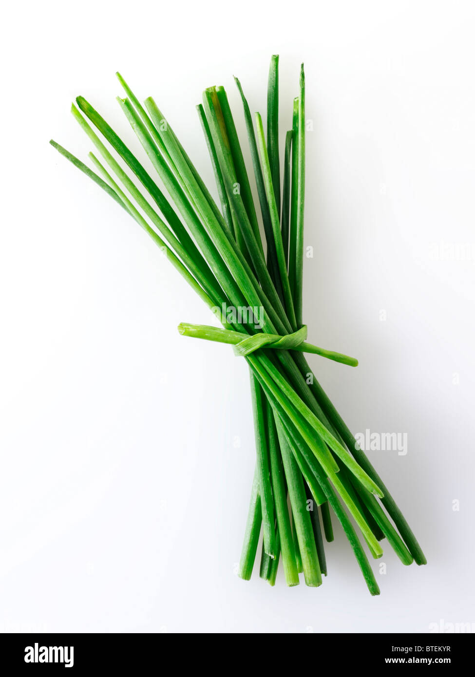 Top shot of a Bunch of fresh chives leaves against a white background ...
