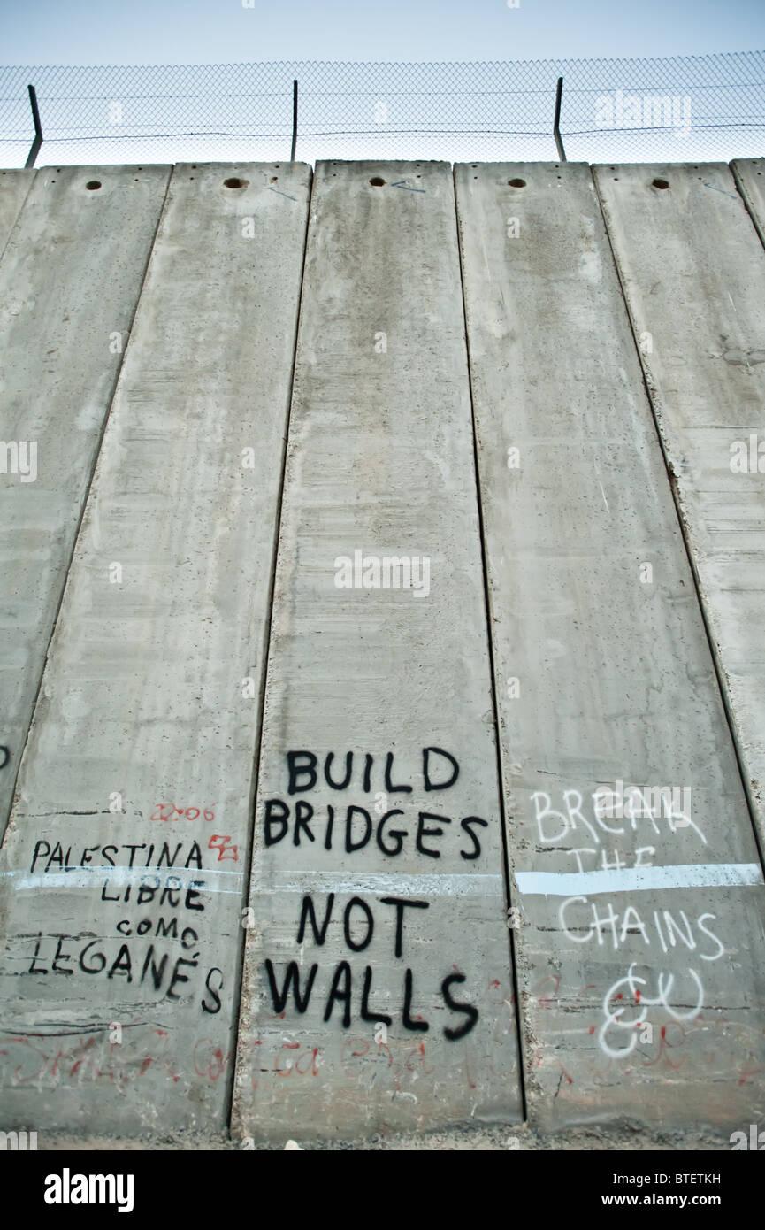 Graffiti on the Israeli separation barrier says, " Build bridges, not ...
