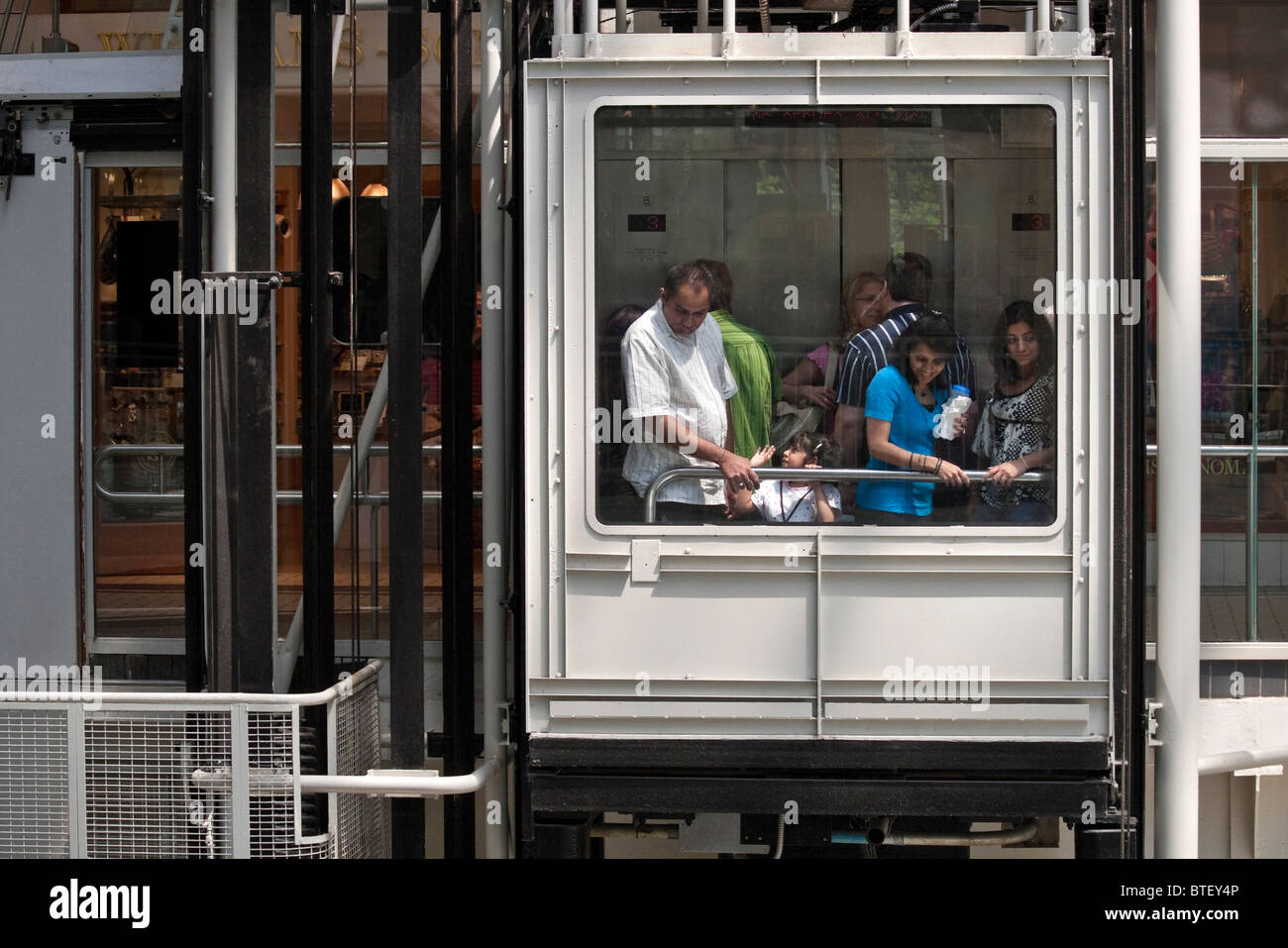 People riding a glass-walled elevator, Toronto Eaton Centre shopping ...