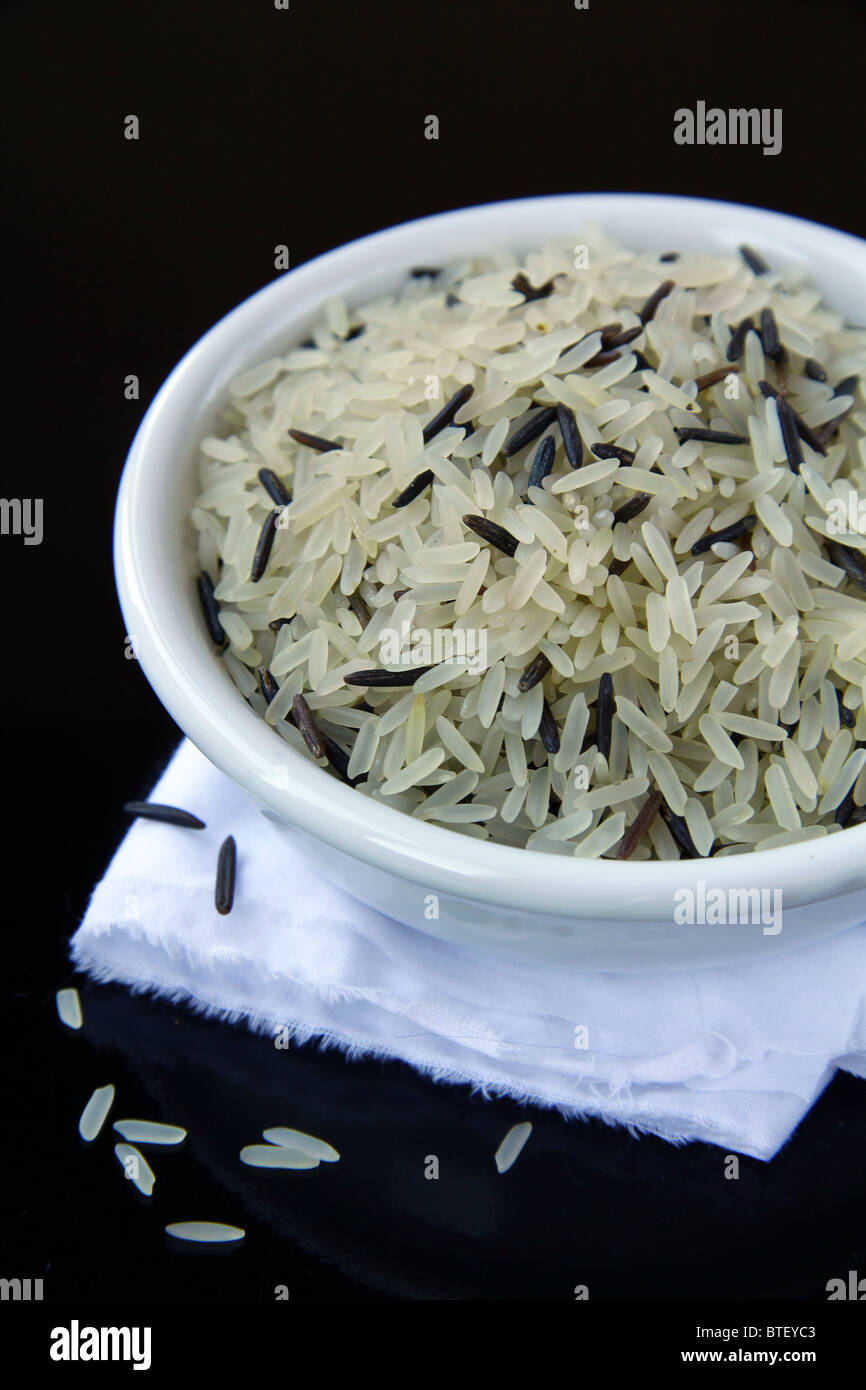 White rice in a cup on black background Stock Photo - Alamy