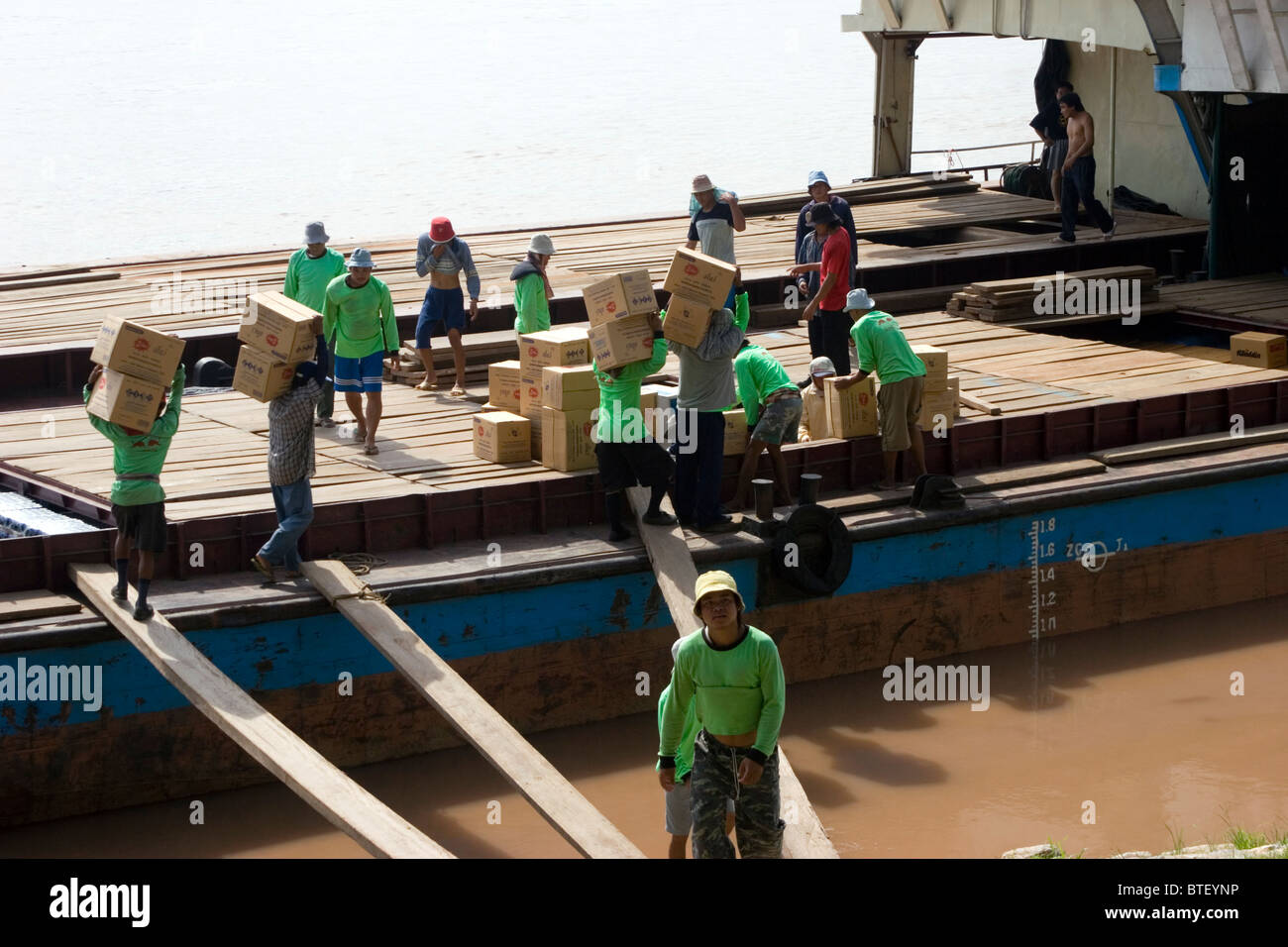 Chinese laborers are loading a cargo boat with boxes of goods on the ...