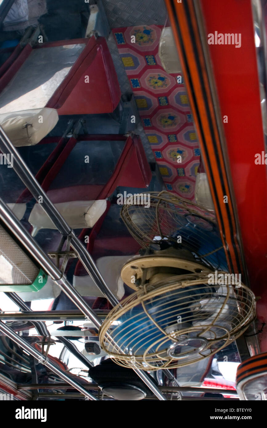A colorful bus is kept cool with an electric fan in Chiang Sean ...