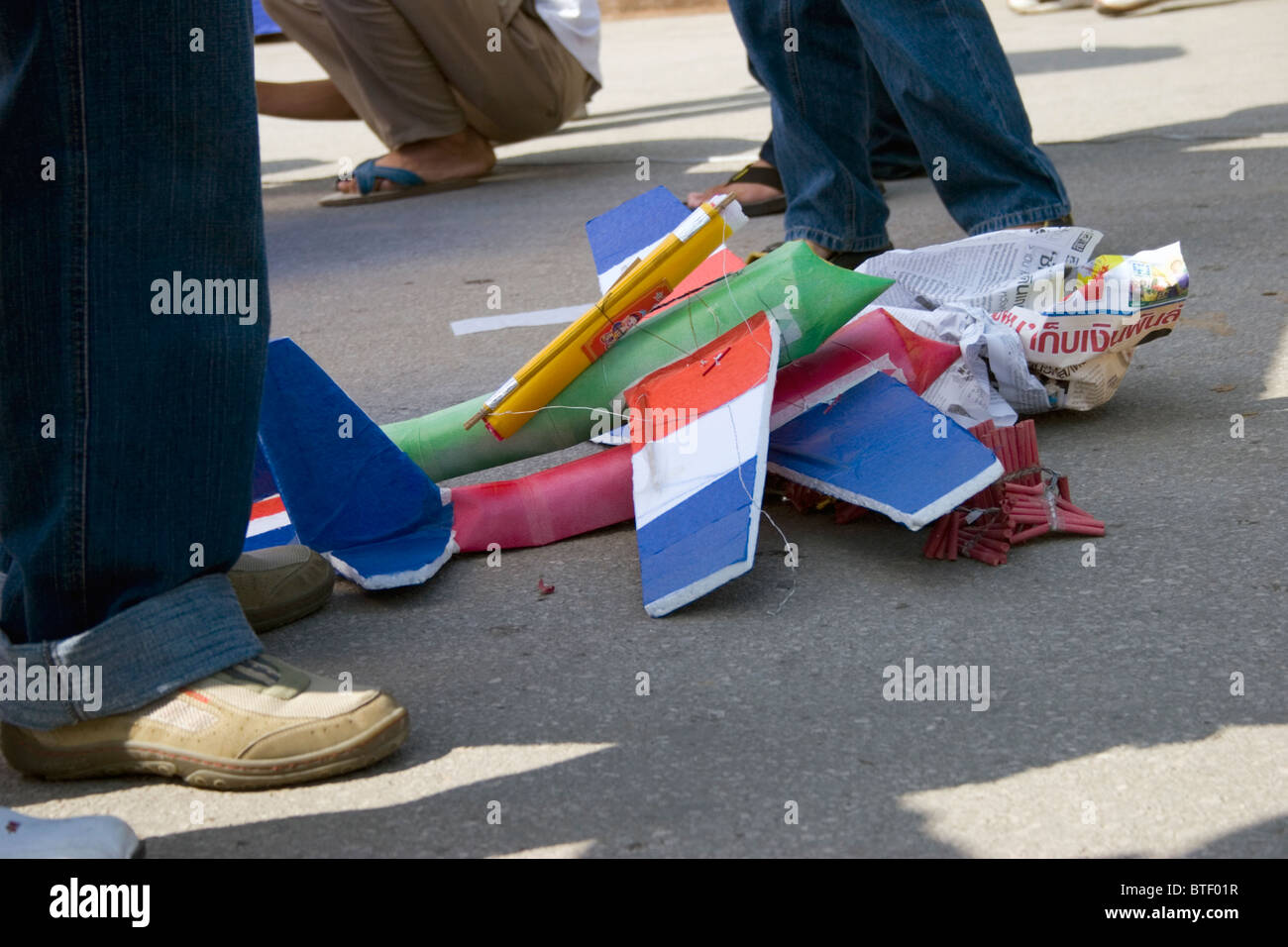 A model airplane with a string of firecrackers is sitting on a street ...