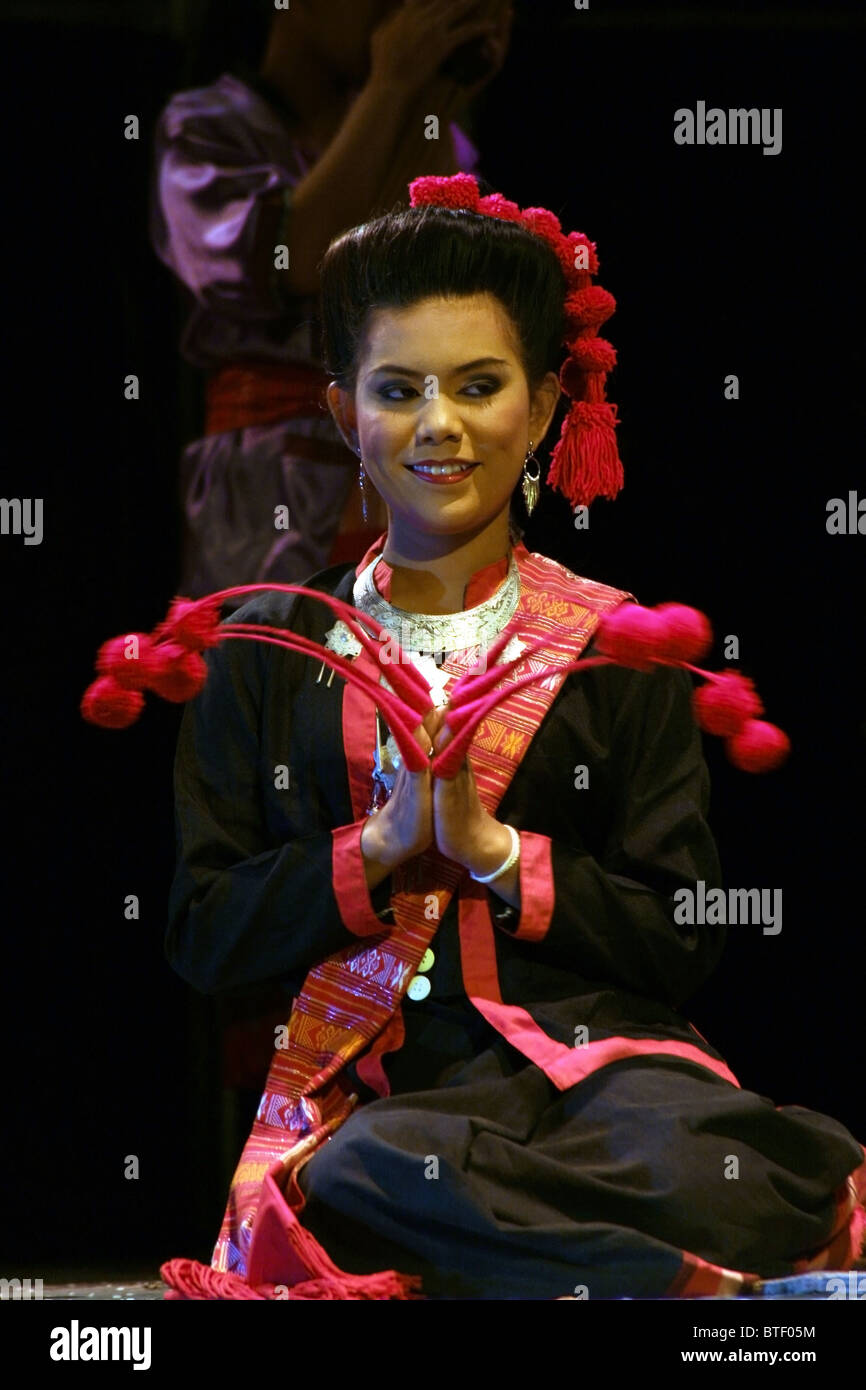 A woman dancer wearing a colorful Thai costume is performing at a dance ...