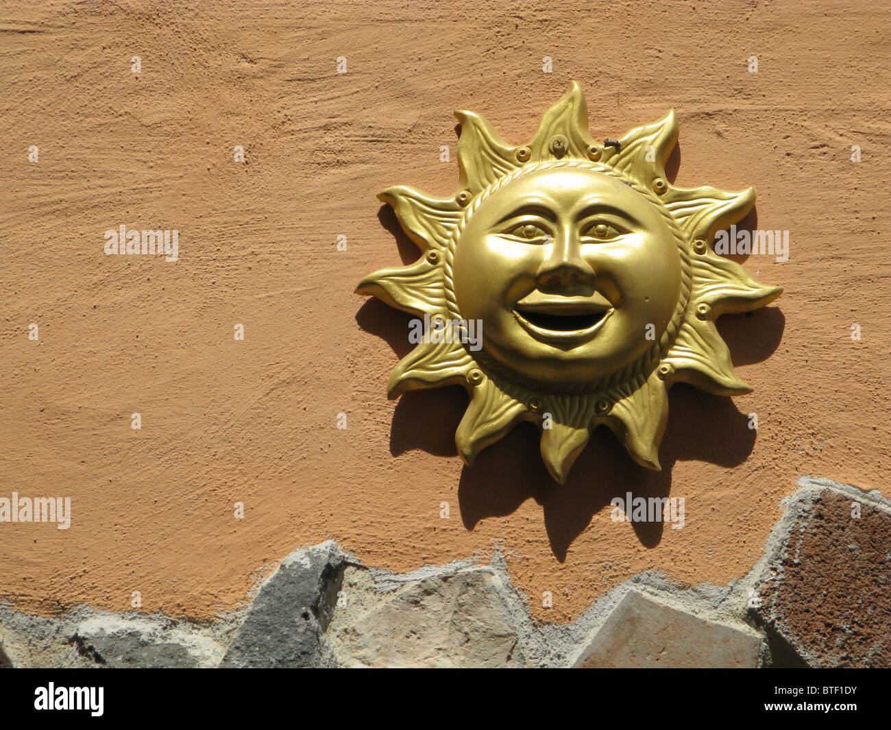 happy sun model plaque on wall in italy Stock Photo - Alamy