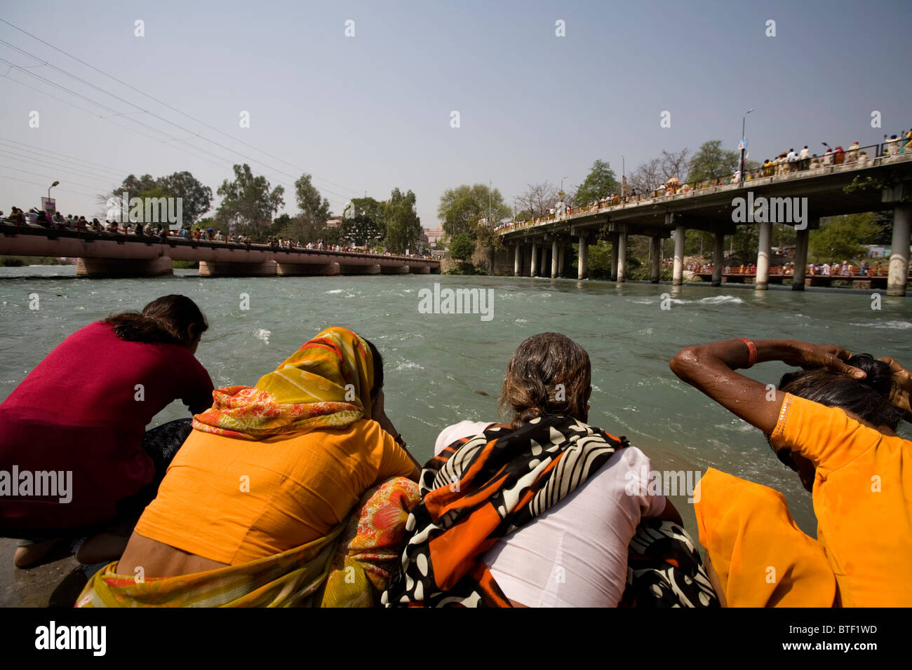 Women cleaning clothes in the river Ganges during the kumbh mela ...