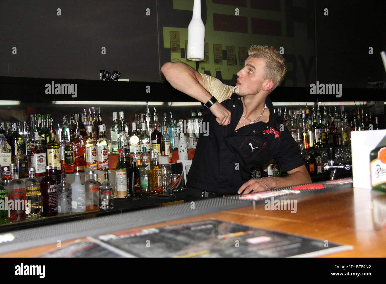Bar Tender juggling with a bottle Stock Photo - Alamy