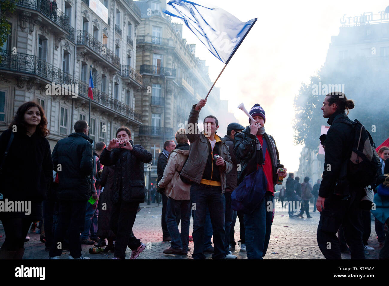 Protester waving flag of left wing political group during demonstration ...
