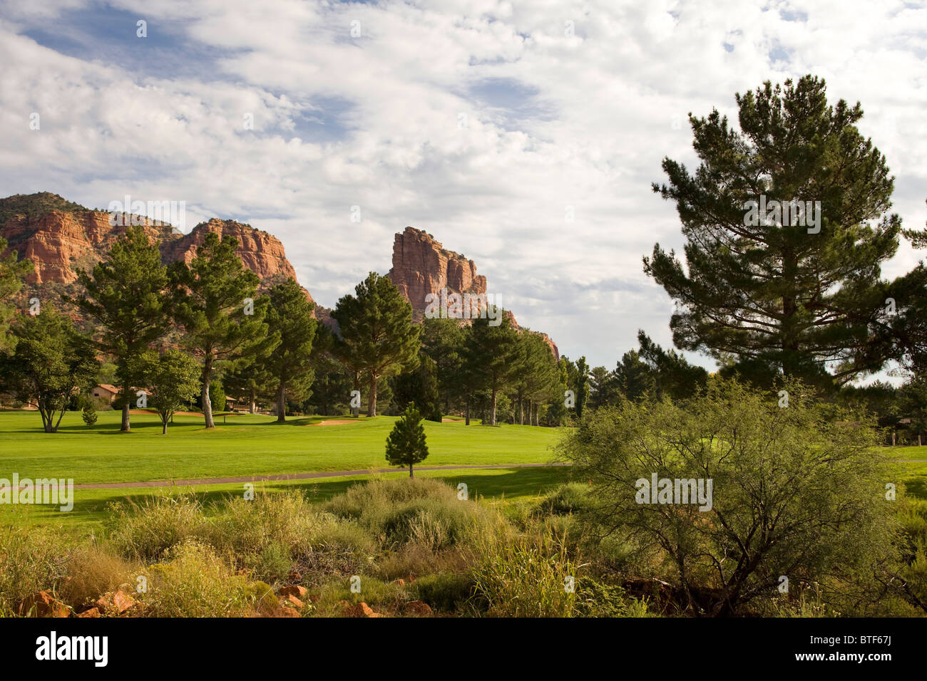 Golf course with exposed sedimentary rock formations in background ...